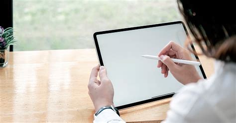 공동 작업 공간에 앉아있는 동안 태블릿 화면에 작성 스타일러스 펜을 사용하여 여성의 손의 클로즈업 이미지 공간을 복사합니다 디지털 태블릿 사용하기에 대한 스톡 사진 및 기타