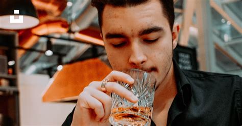 검은 버튼 업 셔츠를 입은 남자는 투명한 음료수 유리에서 마시는 사진 Unsplash의 무료 티미쇼아라 이미지