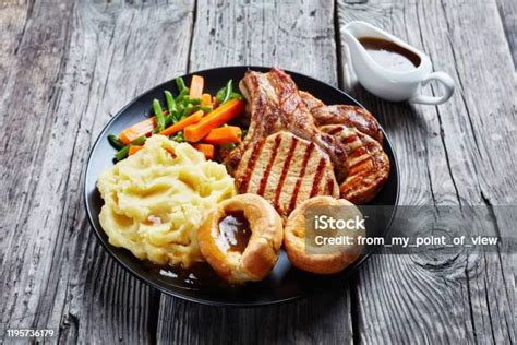 뼈에 구운 돼지 갈비 으깬 감자 녹색 콩 당근 요크셔 푸딩 양파 그레이비를 곁들인 잉글리시 선데이 로스트 0명에 대한 스톡 사진 및 기타 이미지 Istock