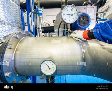 Employee Hand At Pressure Gauge On Chrome Steel Pipe Temperature Gauge At Flange Gate Valves