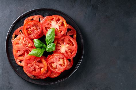 검은 접시에 신선한 바질 잎과 육즙이 많은 토마토 조각 짙은 회색 질감의 배경 평면도 복사 공간 건강한 생활방식에 대한 스톡 사진 및 기타 이미지 Istock
