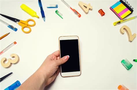 학생은 흰색 배경에서 휴대 전화를 들고 있다 교육의 개념입니다 학교 돌아가기 바탕 화면에 크리에이 티브 엉망입니다 책상입니다 편지지입니다 스마트폰입니다 텍스트에 대 한