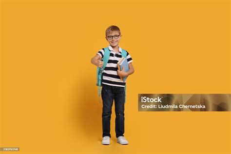 책가방과 함께 안경을 쓴 행복 한 남학생이 주황색 배경에 엄지 손가락을 위로 제스처를 보여줍니다 6 7 살에 대한 스톡 사진 및 기타 이미지 Istock