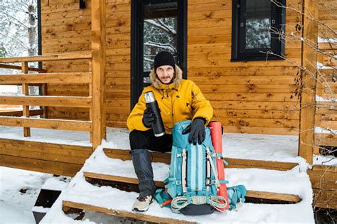 미소 짓고 행복한 여행자는 보온병에서 뜨거운 차나 커피를 마실 것입니다 눈 덮인 숲과 바위 겨울에 산을 오르다 야생에서의 생존 35 39세에 대한 스톡 사진 및 기타 이미지