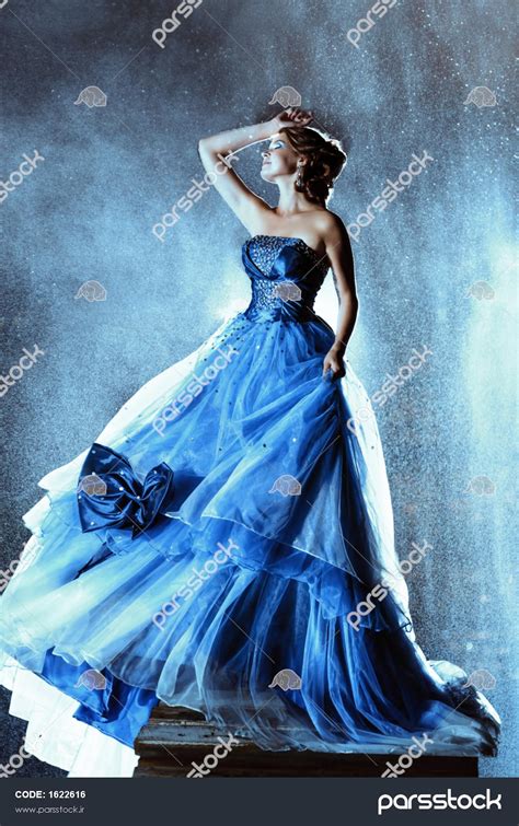 خانمی زیبا با لباس آبی در حال قدم زدن در نزدیکی دریا 1622616