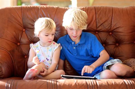 Fratello E Sorella Che Giocano Con Il Pc Della Compressa A Casa