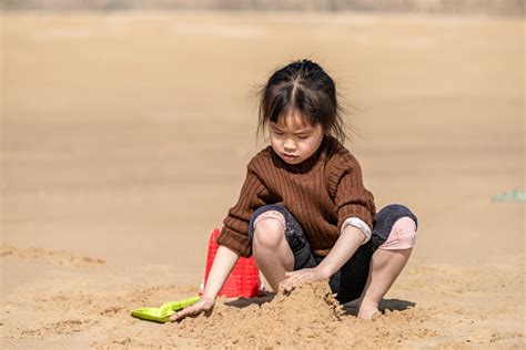 한 소녀가 해변에서 모래놀이를 하는 플라스틱 도구를 만든다 6 7 살에 대한 스톡 사진 및 기타 이미지 6 7 살 경관