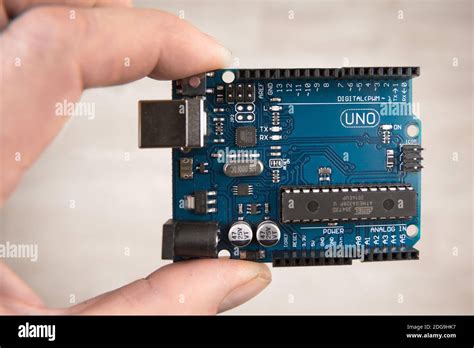Carte électronique Arduino Uno En Main Pour La Programmation Du Microcontrôleur Photo Stock Alamy