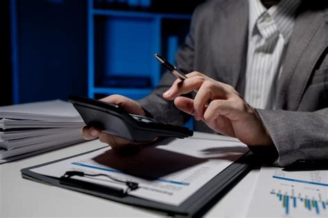 Premium Photo An Employee Is Seriously Calculating Numbers In An Important Document A