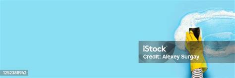 노란색 고무 장갑을 낀 손에는 청소 스폰지를 들고 파란색 배경에 비눗물 거품을 닦습니다 청소 개념 청소 서비스 배너 플랫 레이 상단 보기 가사 집안일에 대한 스톡 사진 및