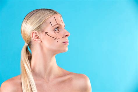 아름 다운 여자 얼굴입니다 금발 젊은 여자의 뷰티 초상화 파란색 배경에 성형 수술에 대 한 얼굴에 라인을 그린 성형 외과의 안 검 성형입니다 리프팅 개선에 대한 스톡 사진
