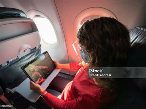 전염병 동안 비행기로 여행하고 태블릿에서 영화를 보는 여성 비행기에 대한 스톡 사진 및 기타 이미지 비행기 영화 지켜 봄 Istock