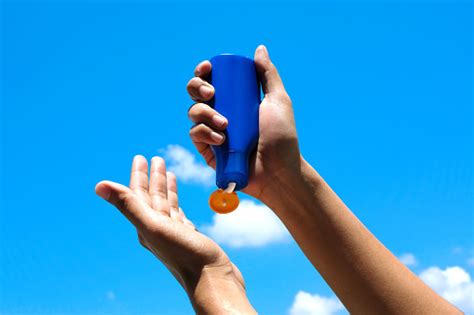 선스크린을 들고 있는 여성의 손 매우 태양 빛 하늘 배경입니다 건강 컨셉과 스킨 케어 개념에 대한 스톡 사진 및 기타 이미지