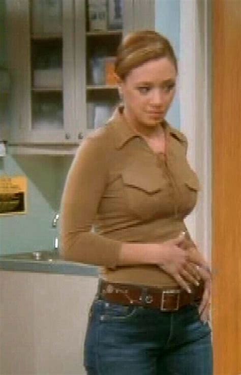 A Woman Standing In A Kitchen With Her Hand On Her Hip