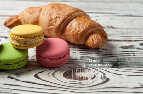 오래된 흰색 소박한 나무 테이블에 다양한 다채로운 마카롱 근처 하나의 전체 구운 크루아상 갈색에 대한 스톡 사진 및 기타 이미지 갈색 널판지 단일 객체 Istock