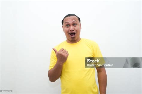 아시아 남자는 손가락으로 옆으로 가리키고 놀라움과 놀람과 놀란 표정 두려움과 흰색 배경에 흥분으로 두려워하고 충격을 받았습니다 가리키기에 대한 스톡 사진 및 기타 이미지