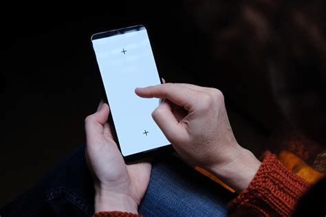 인식 할 수없는 성숙한 여자는 소파에 앉아 스마트 폰과 상호 작용 Brand Name Smart Phone에 대한 스톡 사진 및