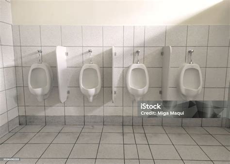 Public Bathroom With Urinals And Intense Light Coming From One Side