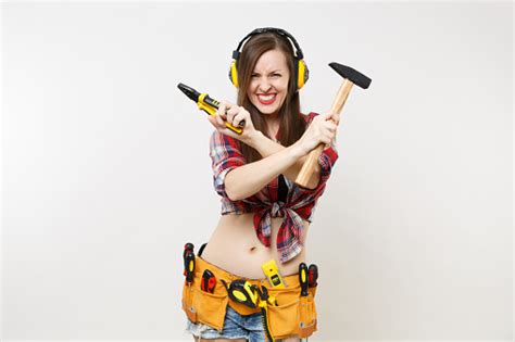 젊은 핸디 여자 최고 격자 무늬 셔츠 데님 반바지 소음 절연 헤드폰 악기의 전체 키트 도구 벨트 흰색 배경에 고립의 강력한 재미 여성 남성 작업입니다 수리 가정 개념입니다