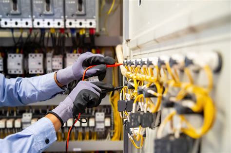 디지털 멀티 미터 측정 장비를 사용하여 주요 배전 기판에서 회로 차단기 및 케이블 배선 시스템에서 전류 전압을 검사하는 전기 엔지니어 검사 보기에 대한 스톡 사진 및 기타