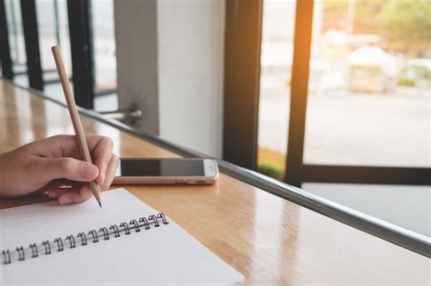 Premium Photo Close Up Woman Hand Is Writting On Notepad With Pencil