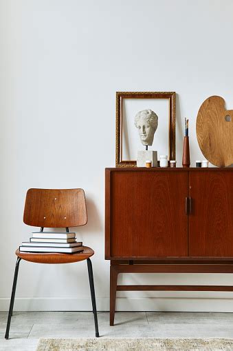 디자인 복고풍 티크 컴모드 의자 책장 포스터 프레임 이젤 장식 및 우아한 개인 액세서리와 아티스트 작업 공간의 세련된 구성