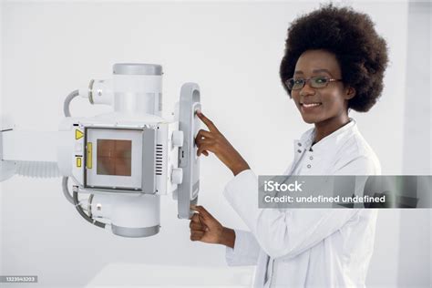 흰색 의료 코트를 입은 아름다운 아프리카 여성 현대 병원 방사선 실에서 X 선 기계 근처에 서 현대 클리닉에서 가슴 심장 폐의 X 선 스캔 Stem 주제에 대한 스톡 사진