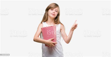 매우 행복 한 측에 손 및 손가락으로 가리키는 팝콘 팩을 들고 젊은 금발 유아 아이에 대한 스톡 사진 및 기타 이미지 아이 쥠 팝콘 Istock