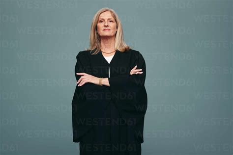 Mature Judge Standing With Her Arms Crossed In A Studio Confident Female Judge Looking At The