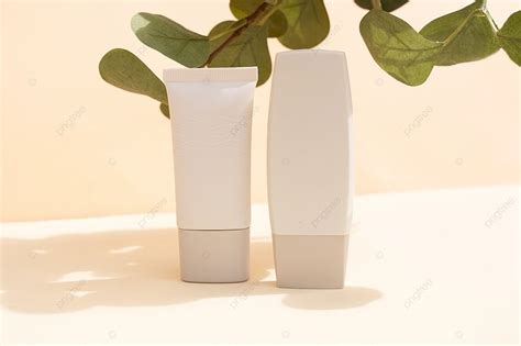 그림자 오버레이가 있는 질감 있는 베이지색 배경에 녹색 잎과 튜브가 있는 최소한의 현대적인 코스메틱 제품 디스플레이 최소 제품 디스플레이 사진 및 무료 다운로드를위한 그림
