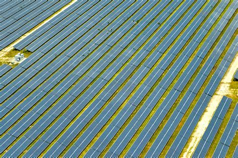 청정 전기 에너지를 생산하기 위한 많은 태양광 전광 패널이 있는 대규모 지속 가능한 전력 발전소의 공중 보기 제로 배출 개념을 가진 재생 가능 전기 Performing