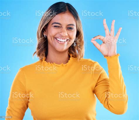 좋아 초상화와 행복한 여자는 파란색 배경 스튜디오 및 지원 계약에 윙크합니다 여성 모델 미소와 성공의 손 예와 완벽한 이모티콘의 우승자 감사 및 검토 승인 20 24세에