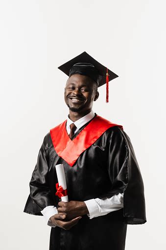 졸업 가운을 입고 흰색 배경에 모자를 쓴 자신감 있는 아프리카 남자 총각 행복하고 재미있는 아프리카 대학원 남자 미소 학생은 대학에서 석사 학위를 취득하고 30 34세에