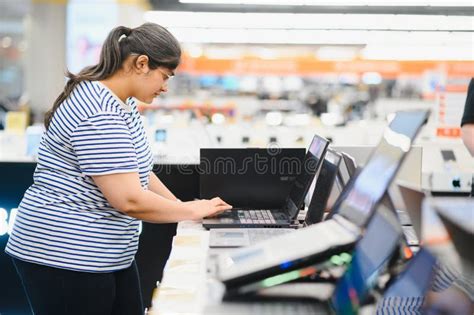 Smart Modern Female Customer Choosing Laptop In The Computer Shop