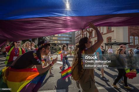 베오그라드 게이 프라이드 동안 거 대 한 무지개 게이 깃발 아래 서 있는 프로충의 군중 퍼레이드는 거 대 한 경찰 시계 아래