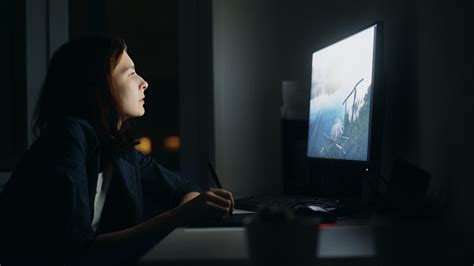 젊은 여성 디자이너 작업 사무실에서 컴퓨터와 그래픽 태블릿을 사용 하 여 작업을 완료 하는 밤에 집중 노트북에 대한 스톡 사진