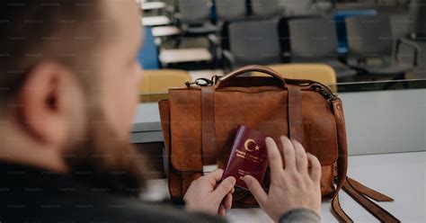 한 남자가 여권과 가방을 들고 있다 사진 Unsplash의 가방 이미지