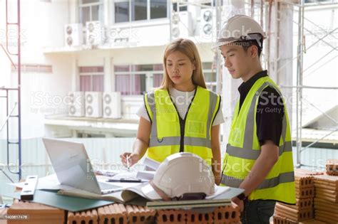 안전 재킷과 헬멧을 착용 한 토목 엔지니어가 건설 현장의 컴퓨터 노트북과 함께 작업합니다 20 24세에 대한 스톡 사진 및 기타 이미지 20 24세 2명 개발