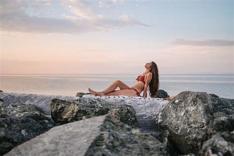 바위 위에서 일광욕을 하는 여성 25 29세에 대한 스톡 사진 및 기타 이미지 25 29세 갈색 머리 경관 Istock