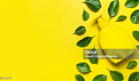 천연 유기농 화장품 아름다움 스파 브랜딩 모형 노란색 화장품 병 용기 신선한 녹색 잎 노란색 배경 평면 평지 상단 보기 포장