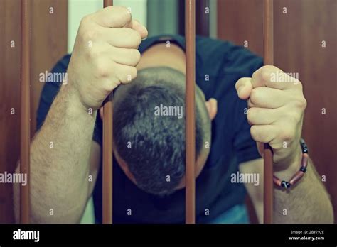 Hands Of The Prisoner On A Steel Lattice Close Up Prison Man In