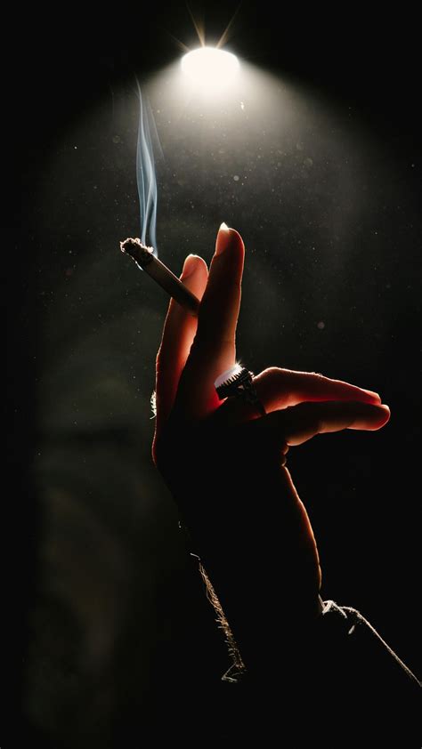 손에 불이 붙은 담배를 들고 있는 사람 사진 Unsplash의 무료 테헤란 이미지