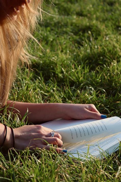 밀라노에서 잔디 위에서 책을 읽는 여성 · 무료 스톡 사진