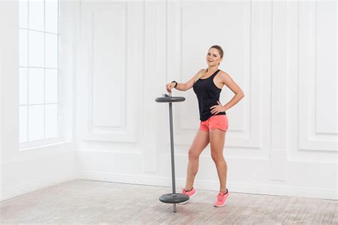 스포티 한 컨셉 만족 운동 젊은 아름 다운 금발의 소녀 핑크 상단과 검은 색 반바지에 서 바 벨을 들고 완벽 한 그림을 보여주는 가정 생활에 대한 스톡 사진 및 기타 이미지