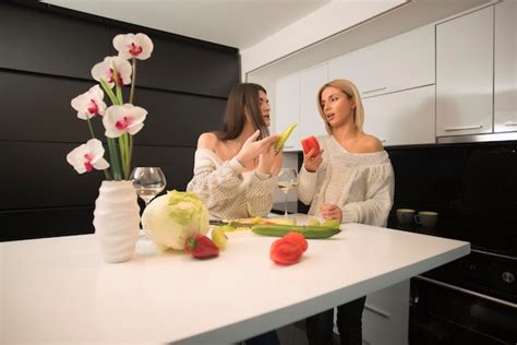 Duas Amigas L Sbicas Fazendo Salada Na Cozinha E Bebendo Vinho Em Ta As De Vinho Foto Premium