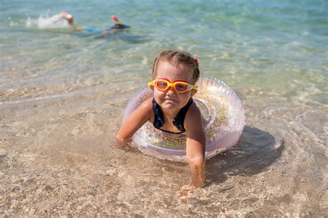 분홍색 수영 반지와 해변에서 재생 즐거운 소녀 여름에바다에서 즐거운 시간을 보내는 아이들 멋진 가족 휴양지 키즈 컨셉을 가진 휴가 2 3 살에 대한 스톡 사진 및 기타