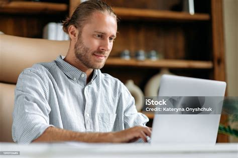 성공적인 스마트 중심의 젊은 백인 Ceo 또는 비즈니스 리더 사무실의 업무용 책상에 앉아 랩톱을 사용하고 인터넷을 탐색하고 프로젝트 아이디어를 찾고 전자 메일에 응답하고