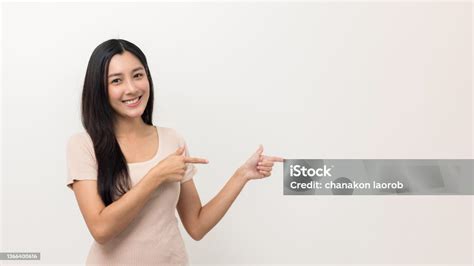 빈 공간에 손가락을 가리키는 아름다운 아시아 여자 고립된 흰색 배경에 미소 짓는 여성 서 포즈 매력적인 십대 소녀 25 텍스트에 대한 빈 공간을 보고 가리키기에 대한 스톡