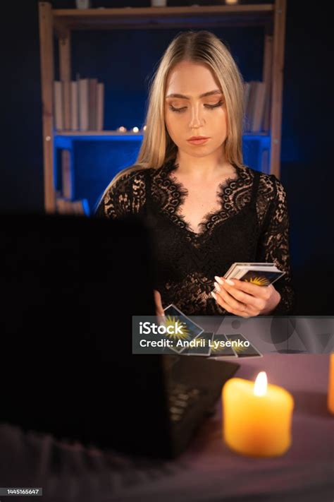 여성 점쟁이는 예측을 위해 타로 카드를 읽고 웹캠 랩톱 컴퓨터 새로운 서비스 및 중소기업을 통해 서비스를 제공하여 고객에게