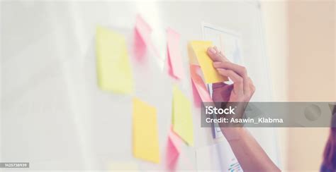 비즈니스 사람들은 사무실에서 만나서 포스트 잇 노트를 사용하여 아이디어를 공유합니다 브레인스토밍 개념 유리 벽에 스티커 메모창조적 인 사무실에서 함께 일하고 의사 소통하는